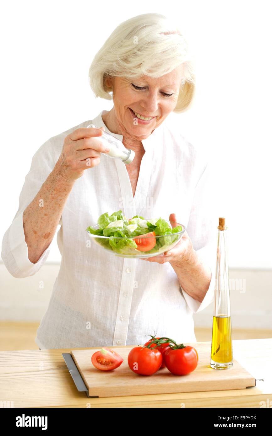 Woman adding salt on a salad Stock Photo - Alamy