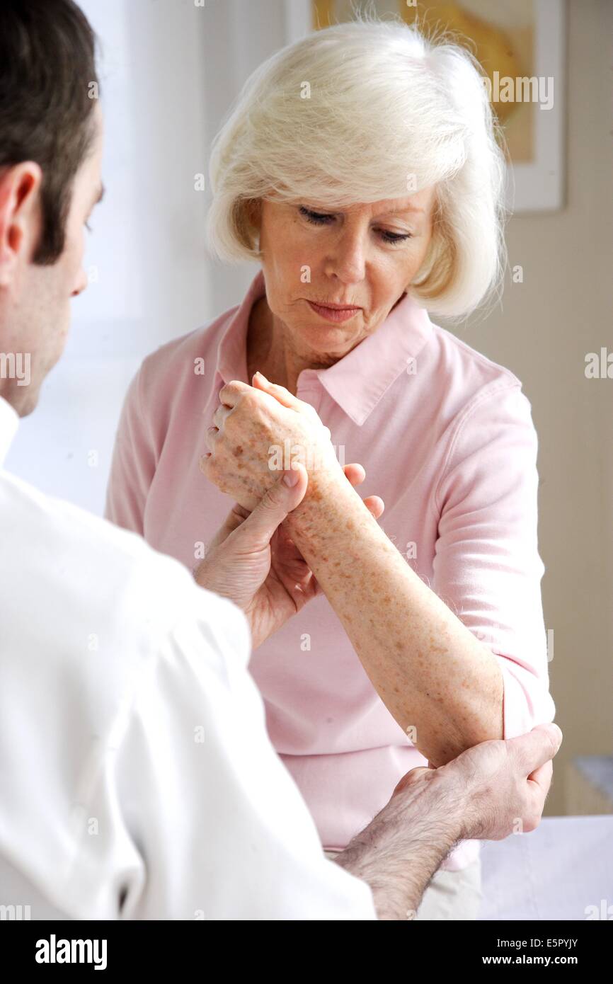 Doctor examining arm of elderly patient Stock Photo - Alamy