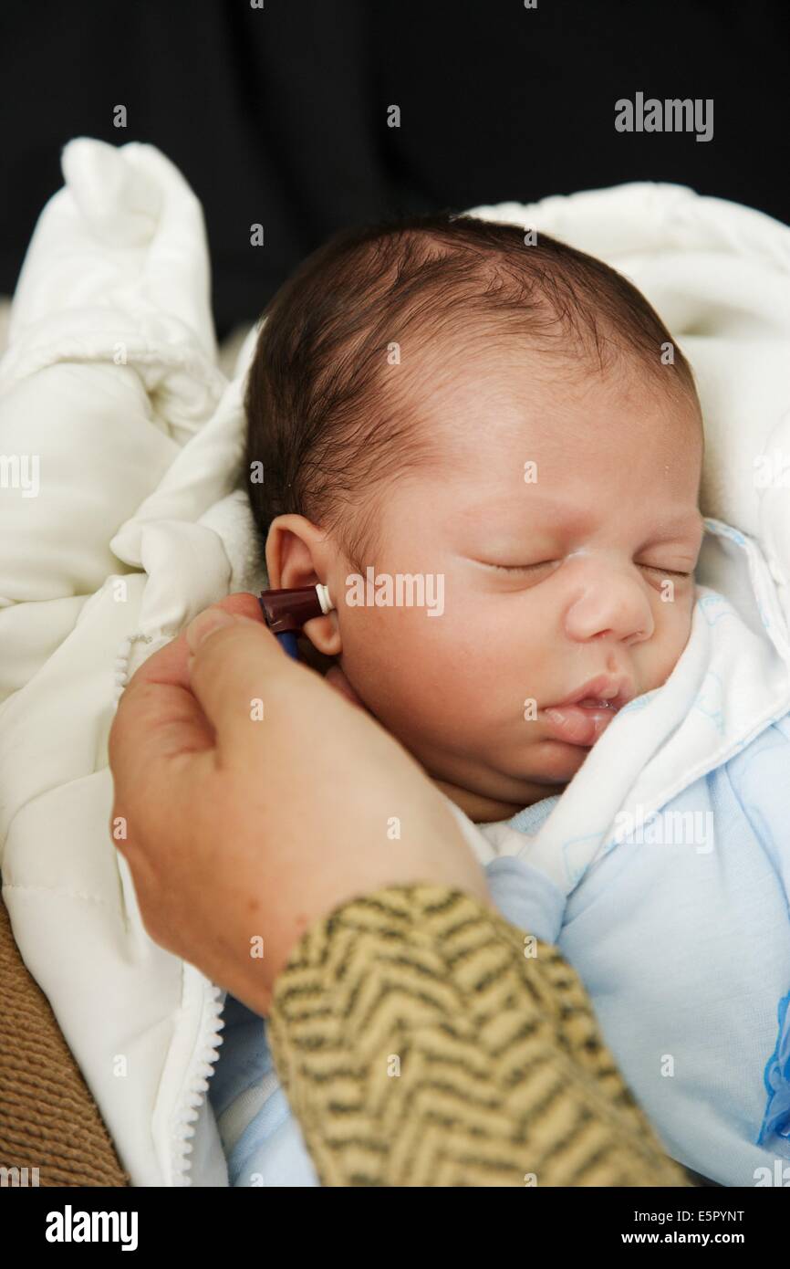 Baby undergoing deafness screening test with the method of otoacoustic ...