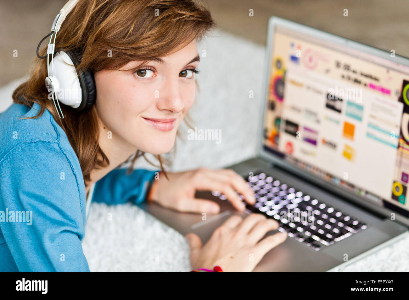 Teenage girl using laptop and listening to music Stock Photo - Alamy