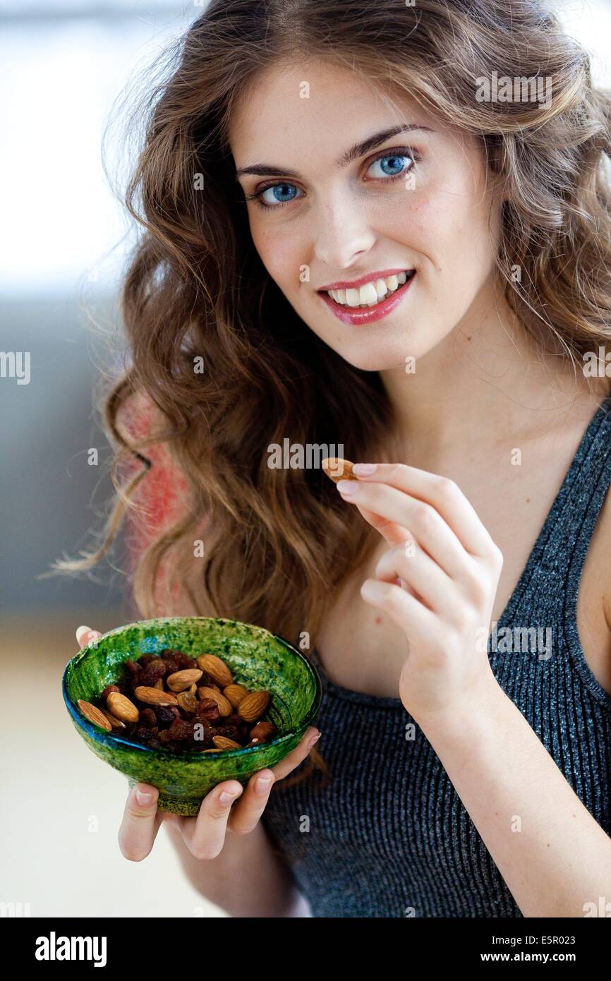 Woman eating several nuts Stock Photo - Alamy