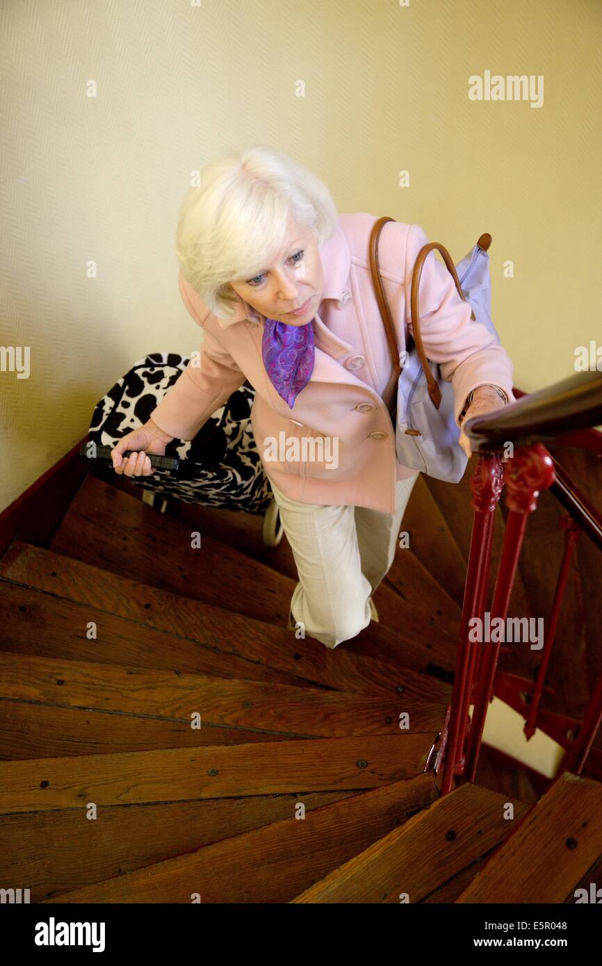 Elderly woman climbing up stairs hi-res stock photography and images ...