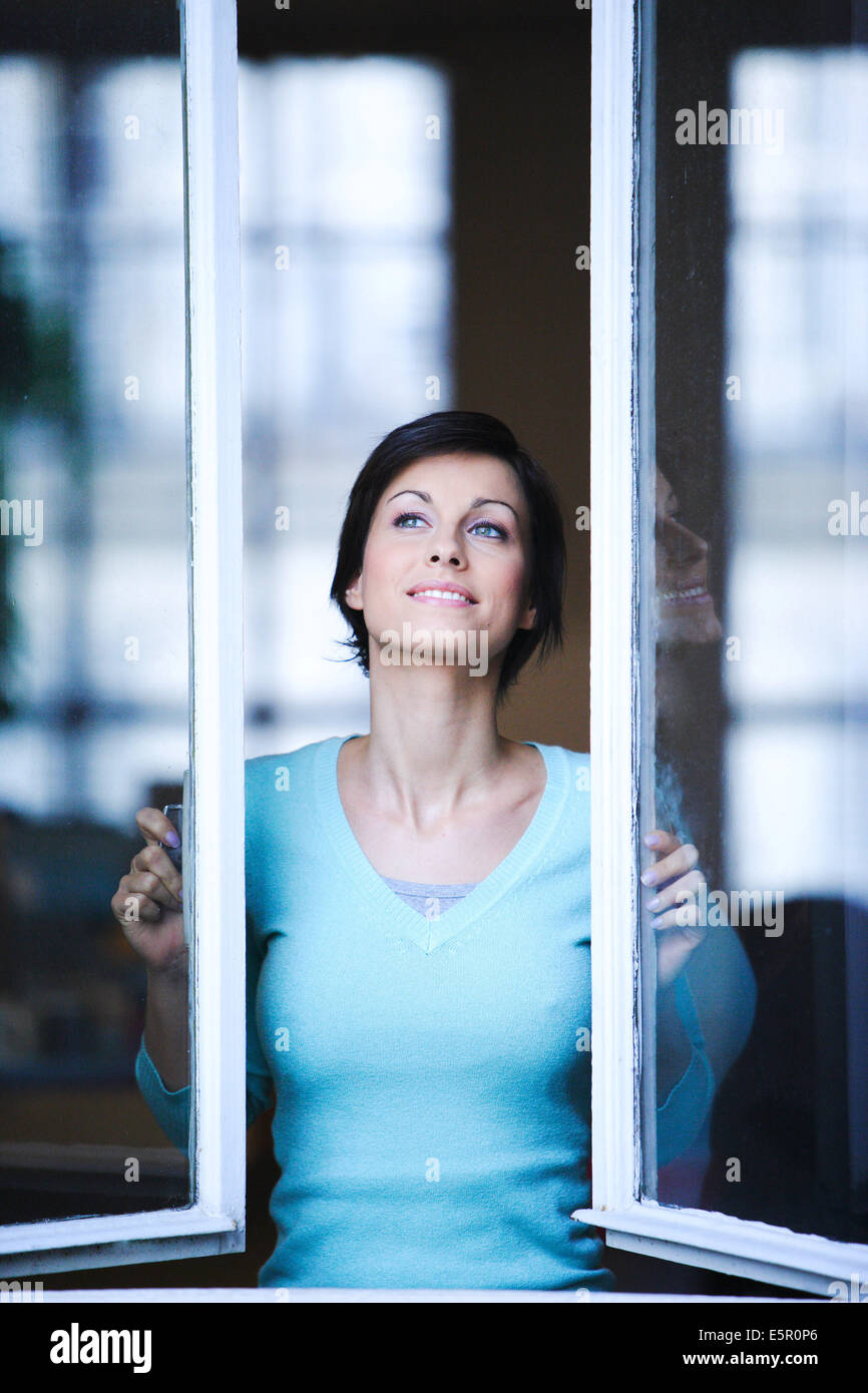 Woman opening window Stock Photo - Alamy