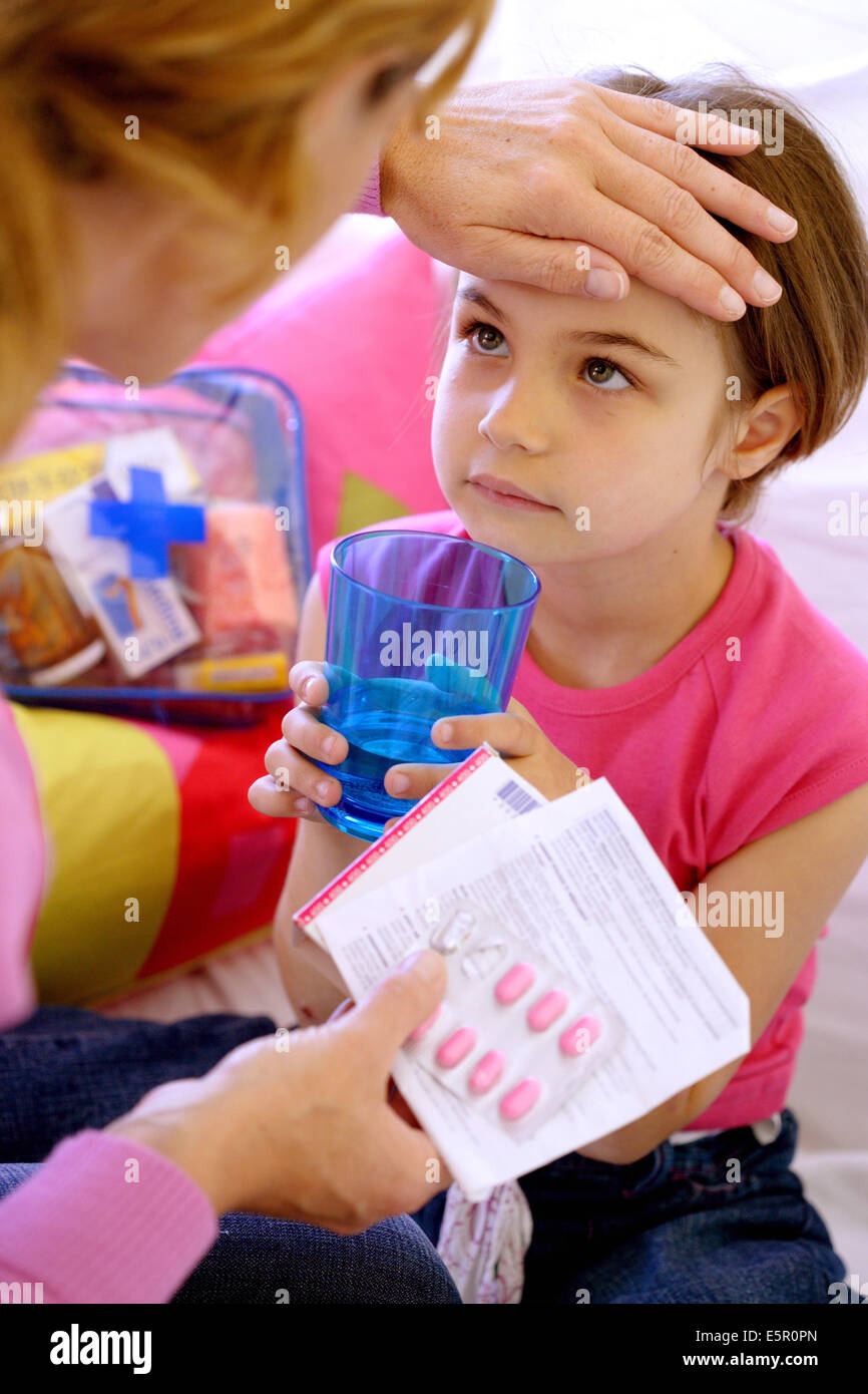 Woman giving a feverish girl medicines Stock Photo - Alamy