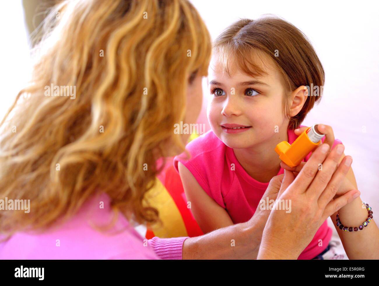 Child using an aerosol inhaler that contains bronchodilator for the ...