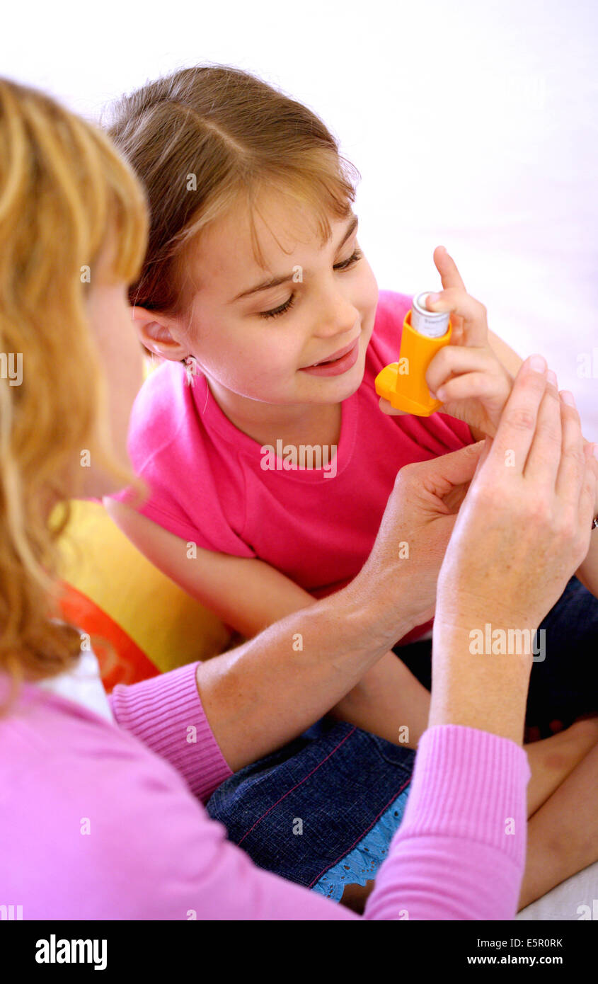 Child using an aerosol inhaler that contains bronchodilator for the ...