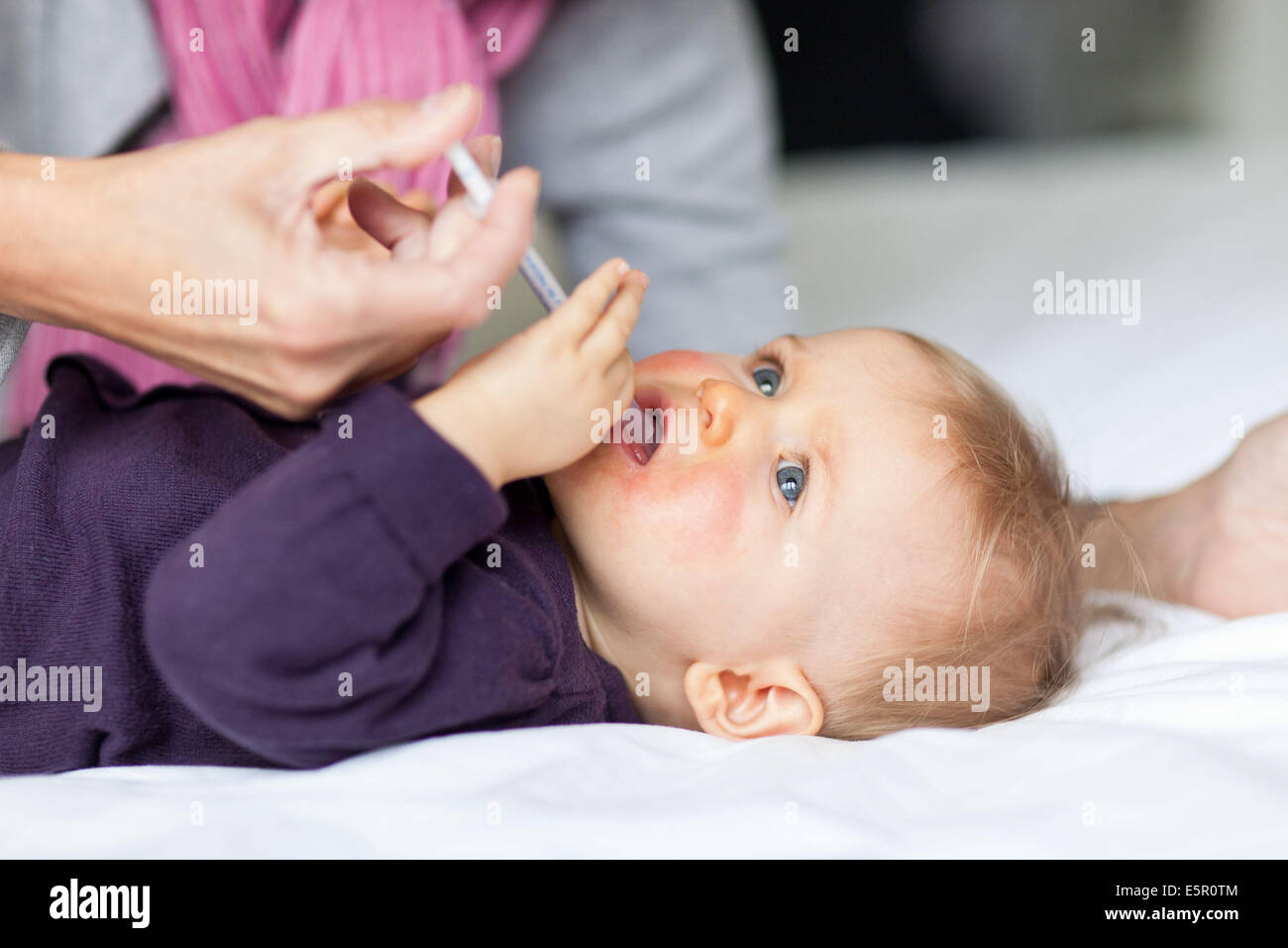 Mother giving her baby medication with a pipette Stock Photo - Alamy