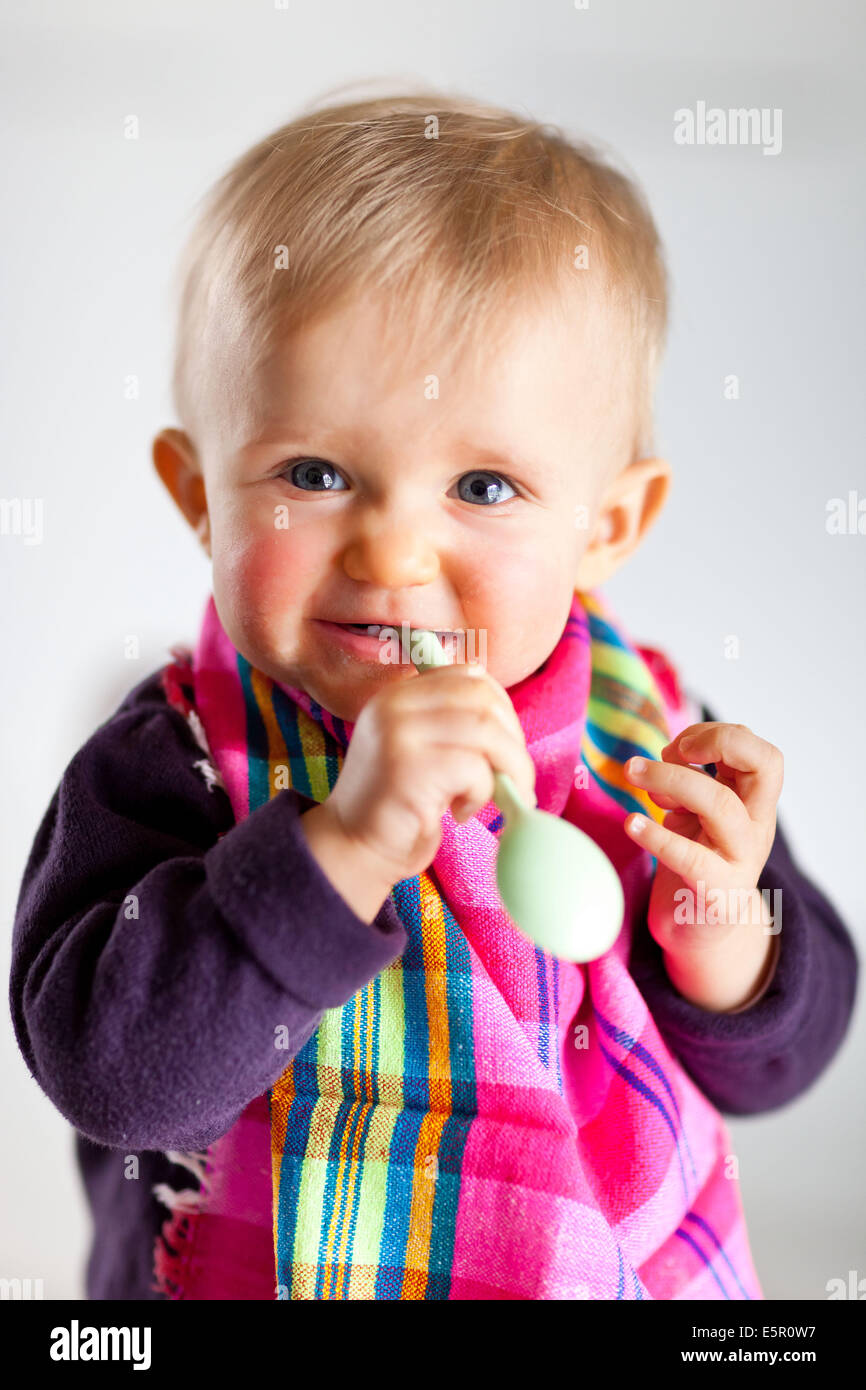 10-month-old baby girl biting spoon Stock Photo - Alamy