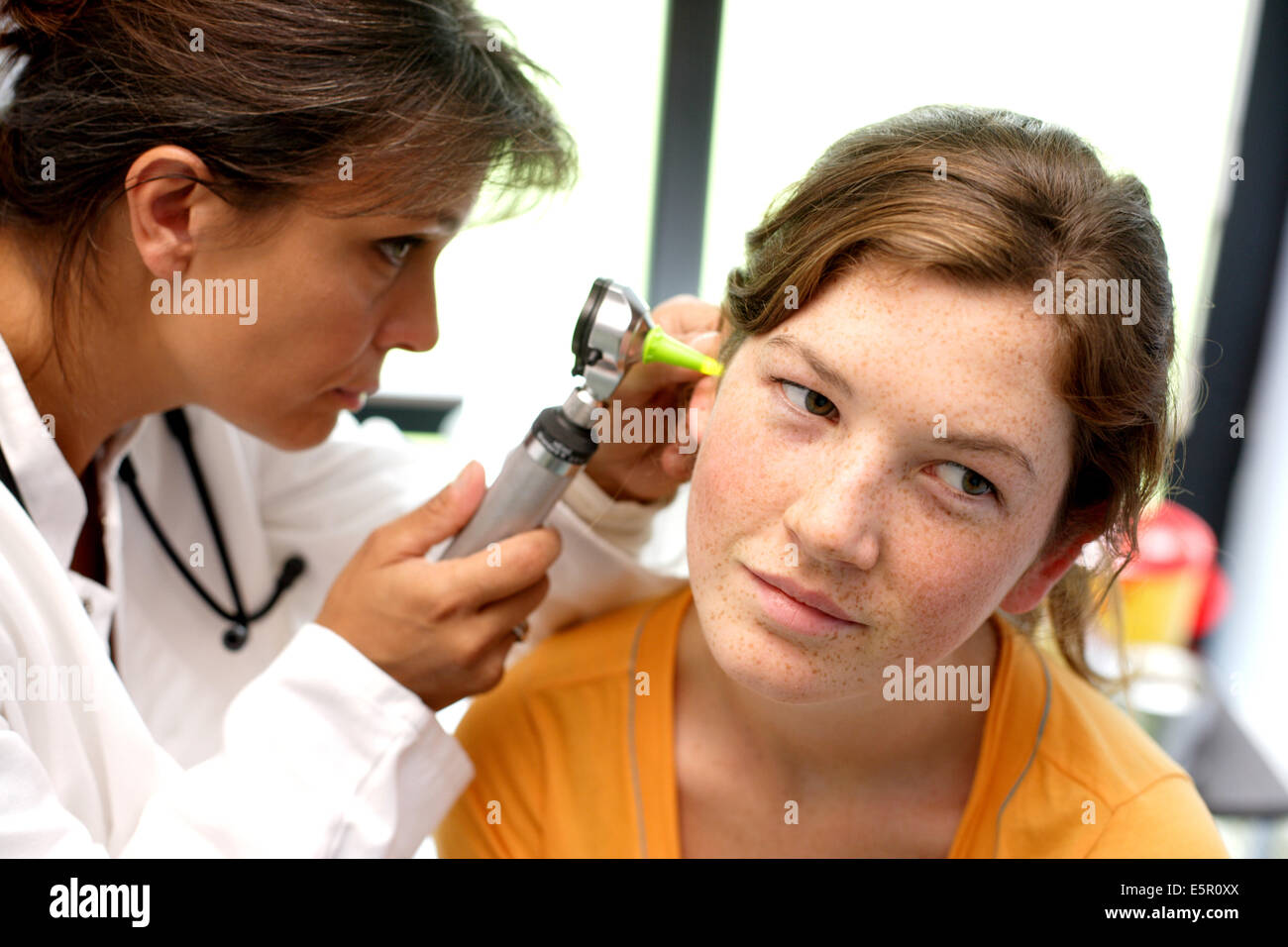 Doctor examining the ears of a patient with an otoscope Stock Photo - Alamy