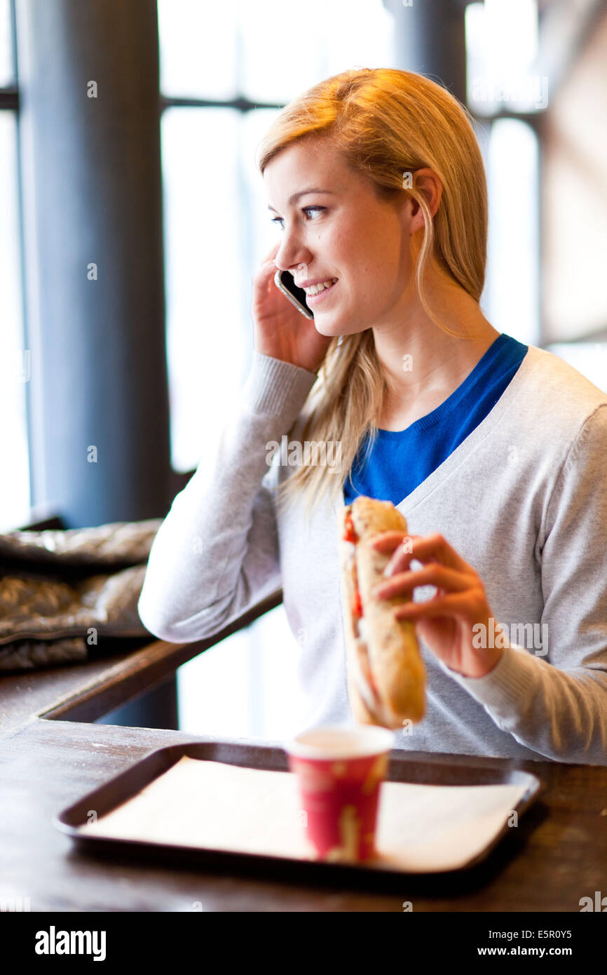 Woman having lunch in fast-food restaurant Stock Photo - Alamy