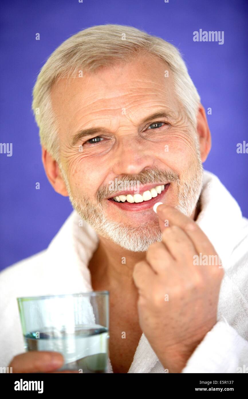 Man taking medicines Stock Photo - Alamy