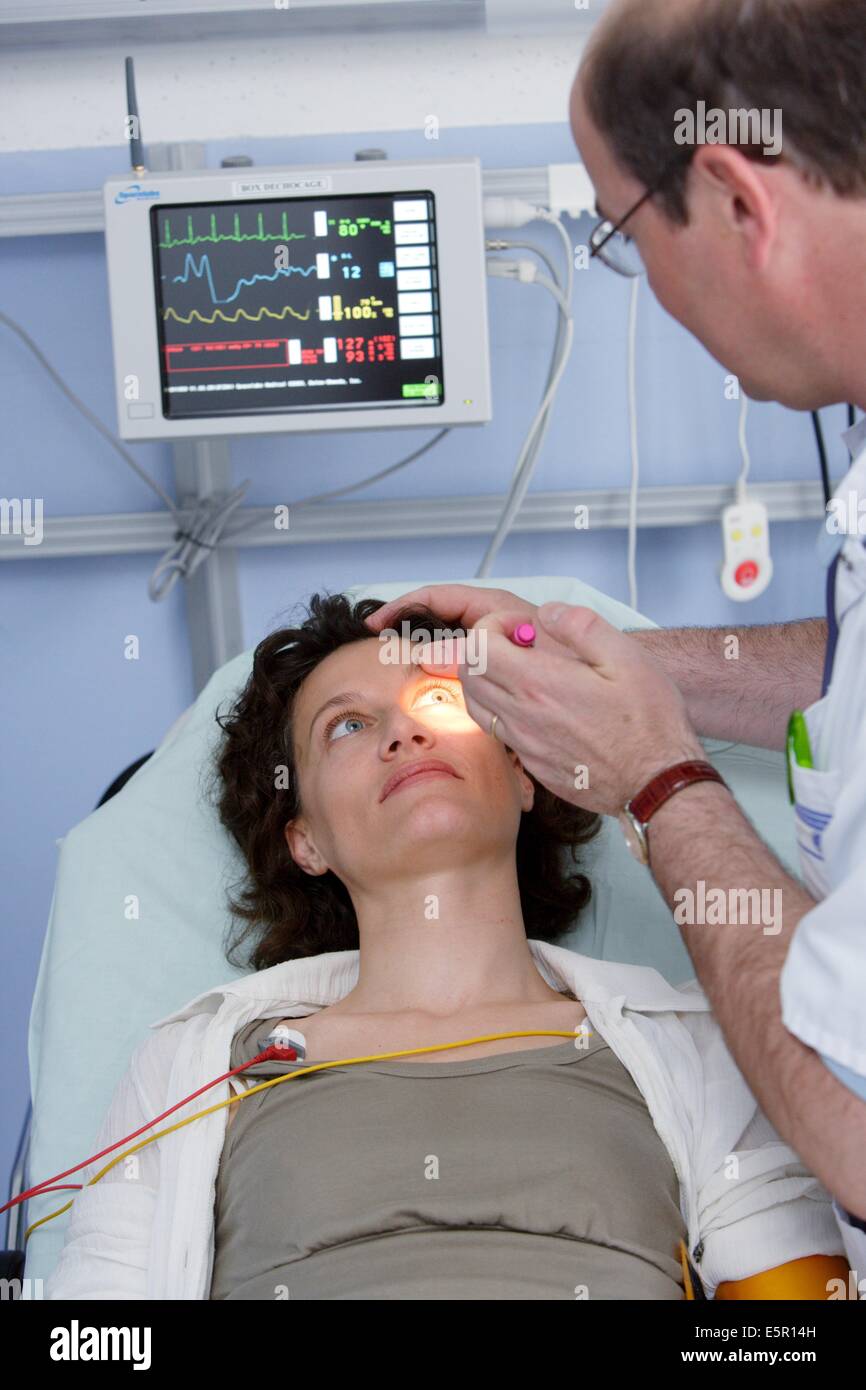 Assessing pupil dilation : hospital doctor performing neurological ...