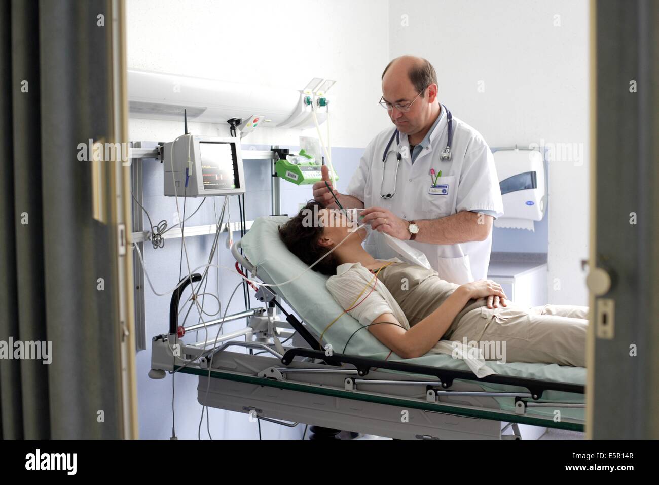 Hospital doctor setting oxygen mask on patient's face for respiratory ...