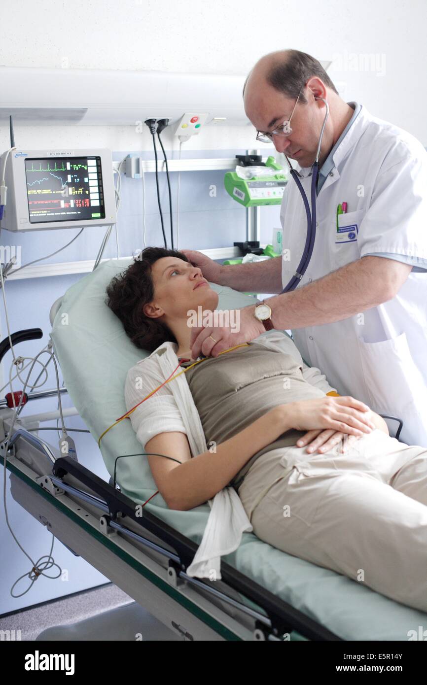 Hospital doctor examining a patient with a stethoscope at emergency ...