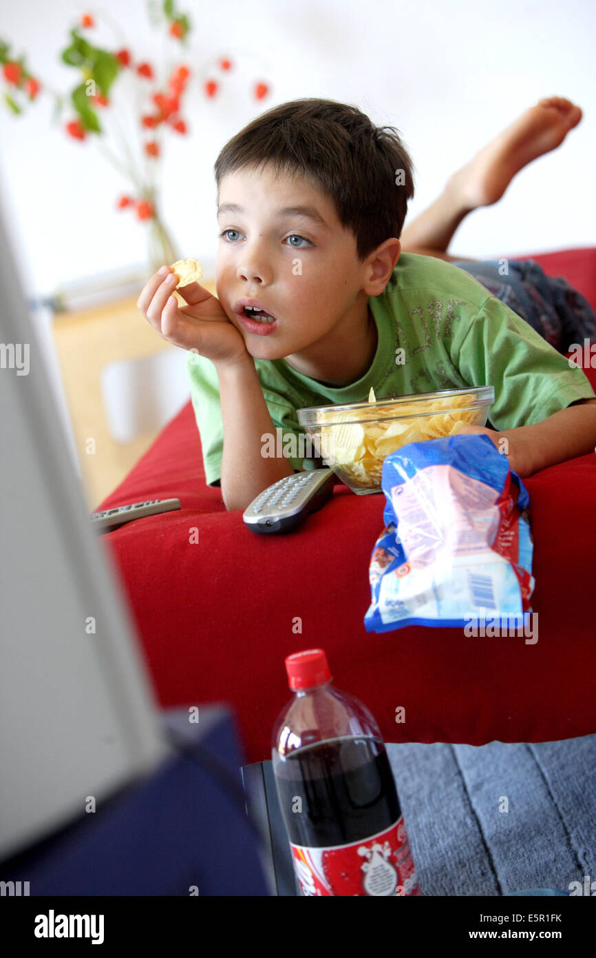 Child snacking while watching TV Stock Photo - Alamy