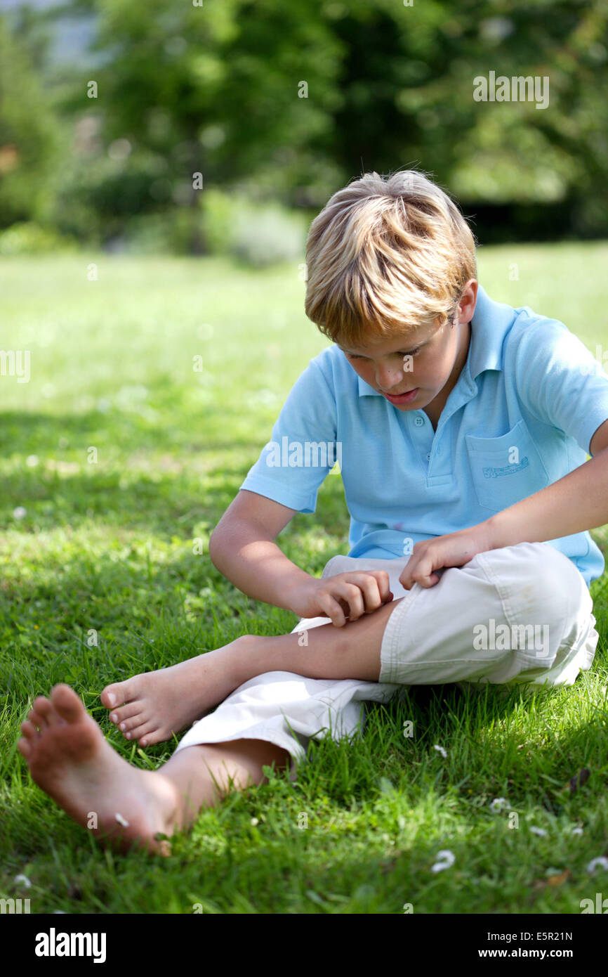 Boy scratching his leg hi-res stock photography and images - Alamy