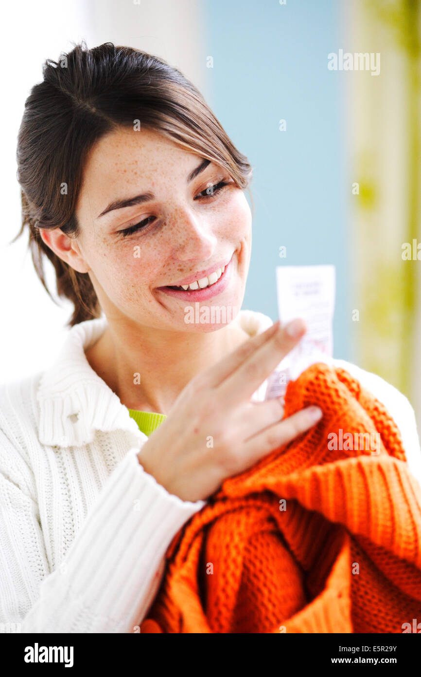 Woman reading a cloth care label Stock Photo - Alamy