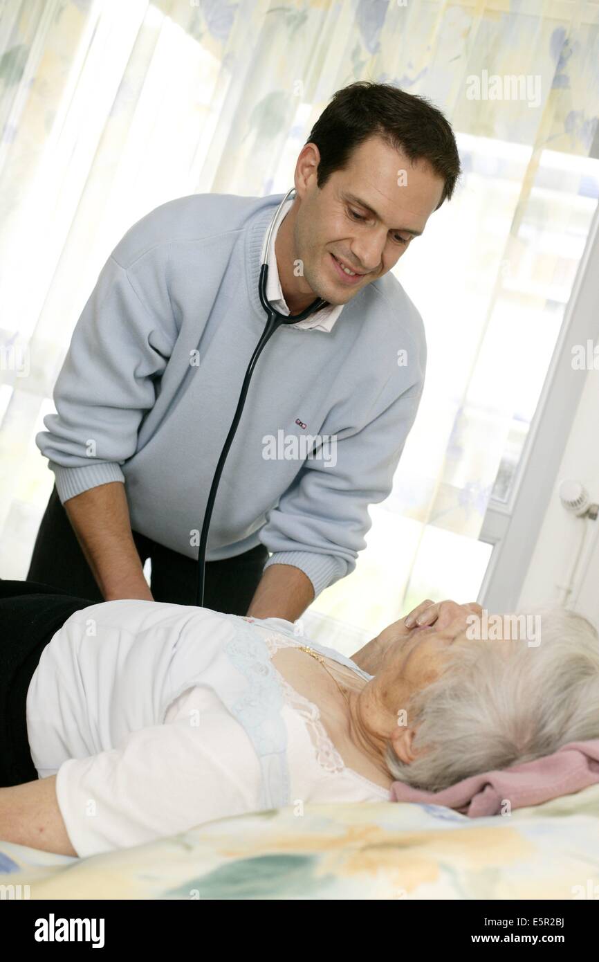 General practitioner examining an elderly person during a visit in a ...