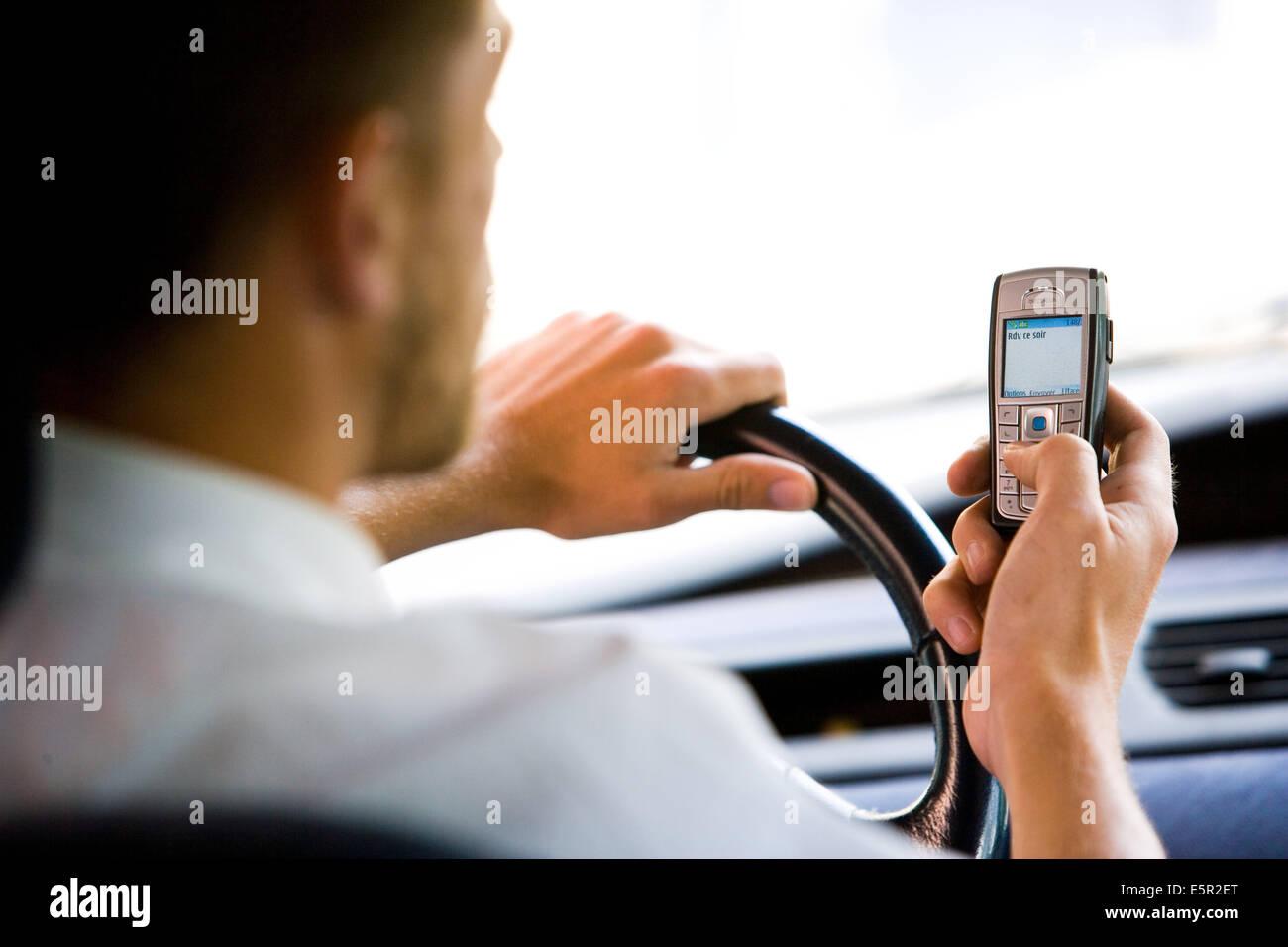 Man using a cell phone while driving Stock Photo - Alamy