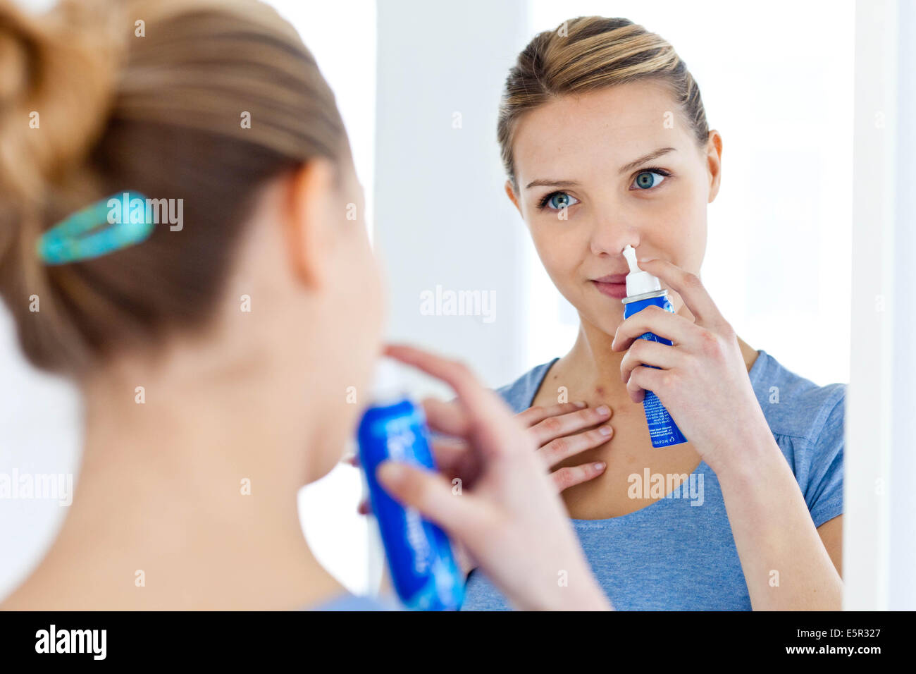 Woman using a sterile sea water spray Stock Photo - Alamy