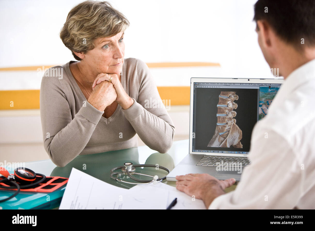 Doctor discussing backbone 3D CT scan with a patient Stock Photo - Alamy
