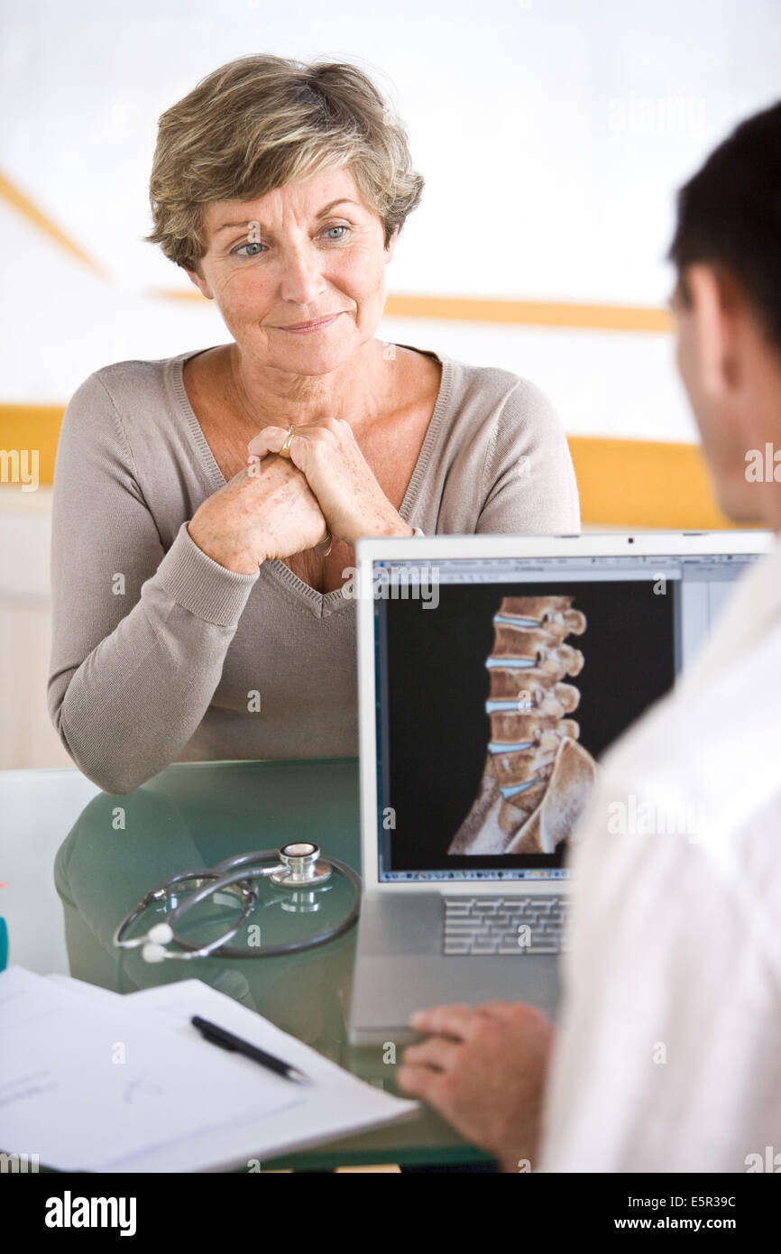Doctor discussing backbone 3D CT scan with a patient Stock Photo - Alamy