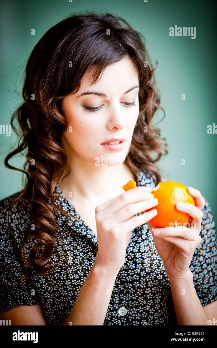 Woman peeling an orange Stock Photo - Alamy