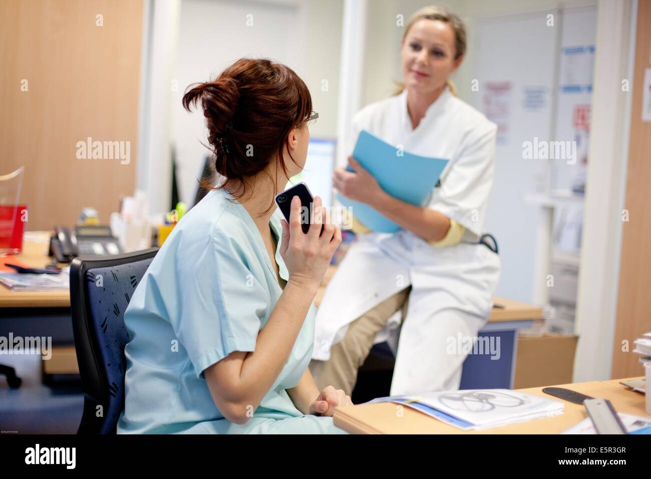 Doctor and nurse discussing Stock Photo - Alamy