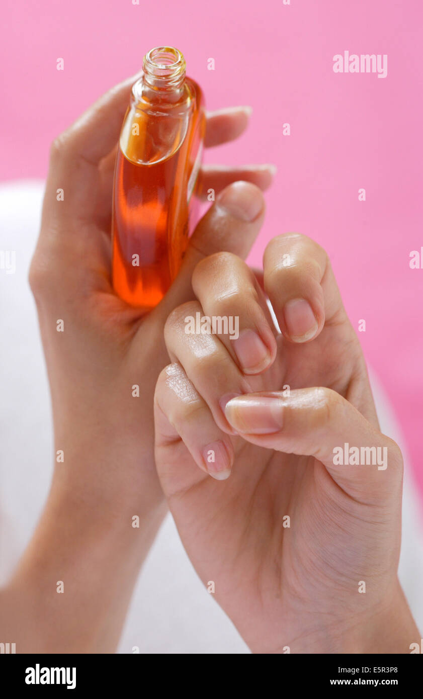 Woman using body oil Stock Photo - Alamy