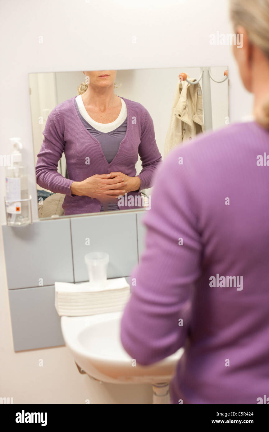 Woman with hands on stomach Stock Photo - Alamy