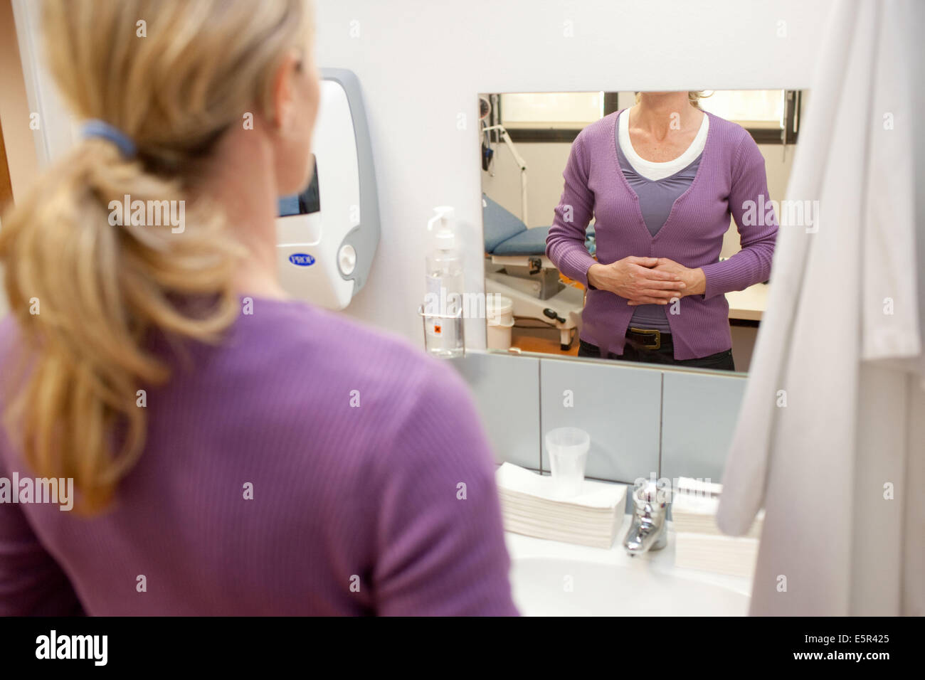 Woman with hands on stomach Stock Photo - Alamy