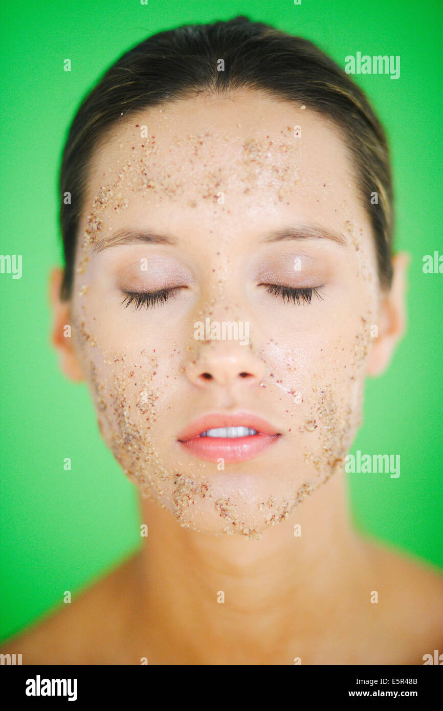 Woman exfoliating her face with facial scrub treatment Stock Photo - Alamy