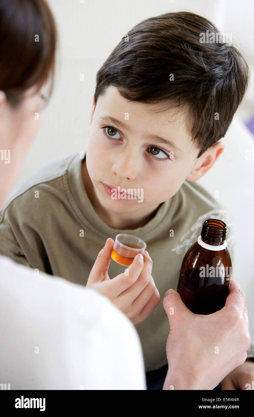 8 year old child taking syrup Stock Photo - Alamy
