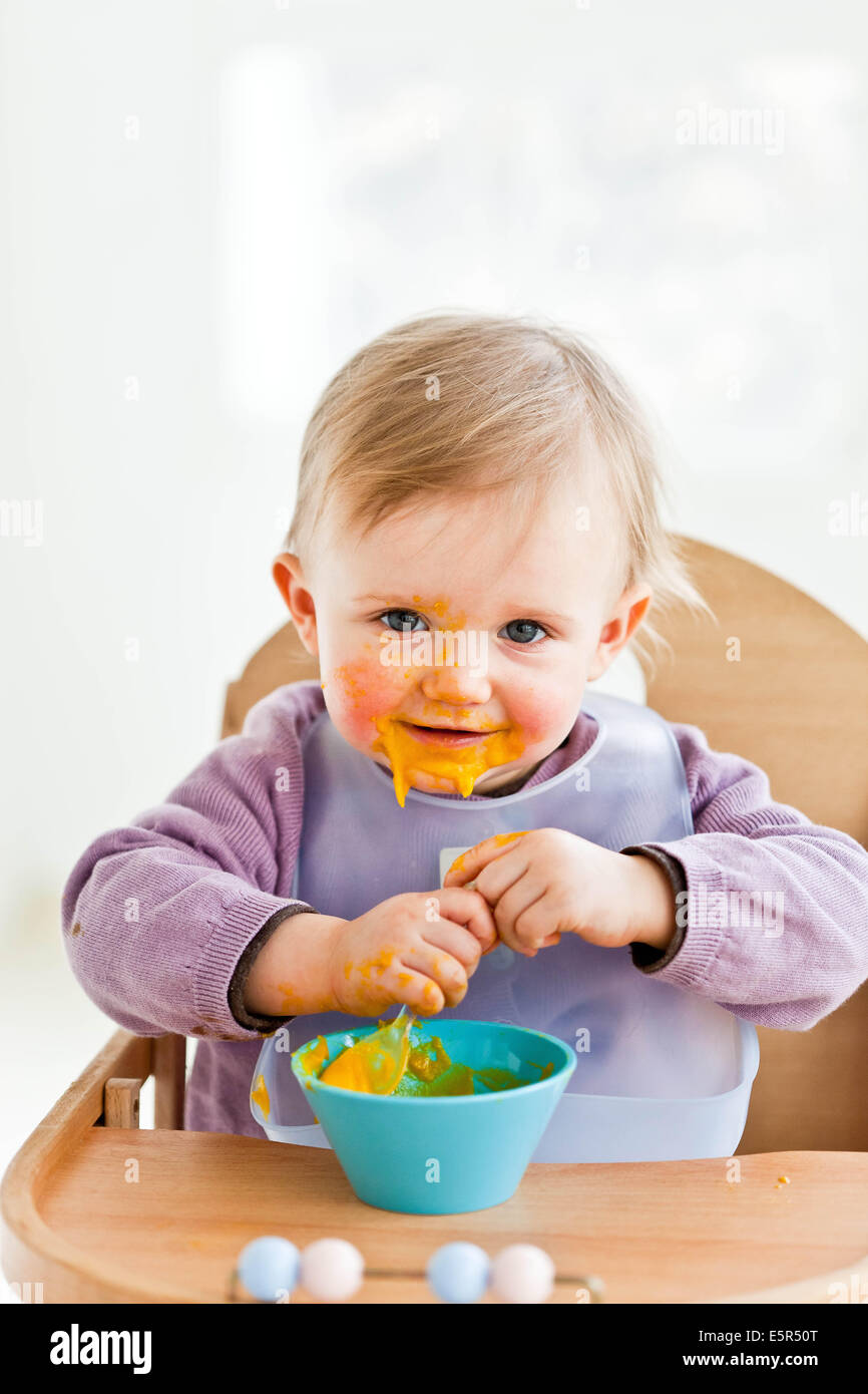 13-month-old baby girl eating alone. Independence training Stock Photo ...