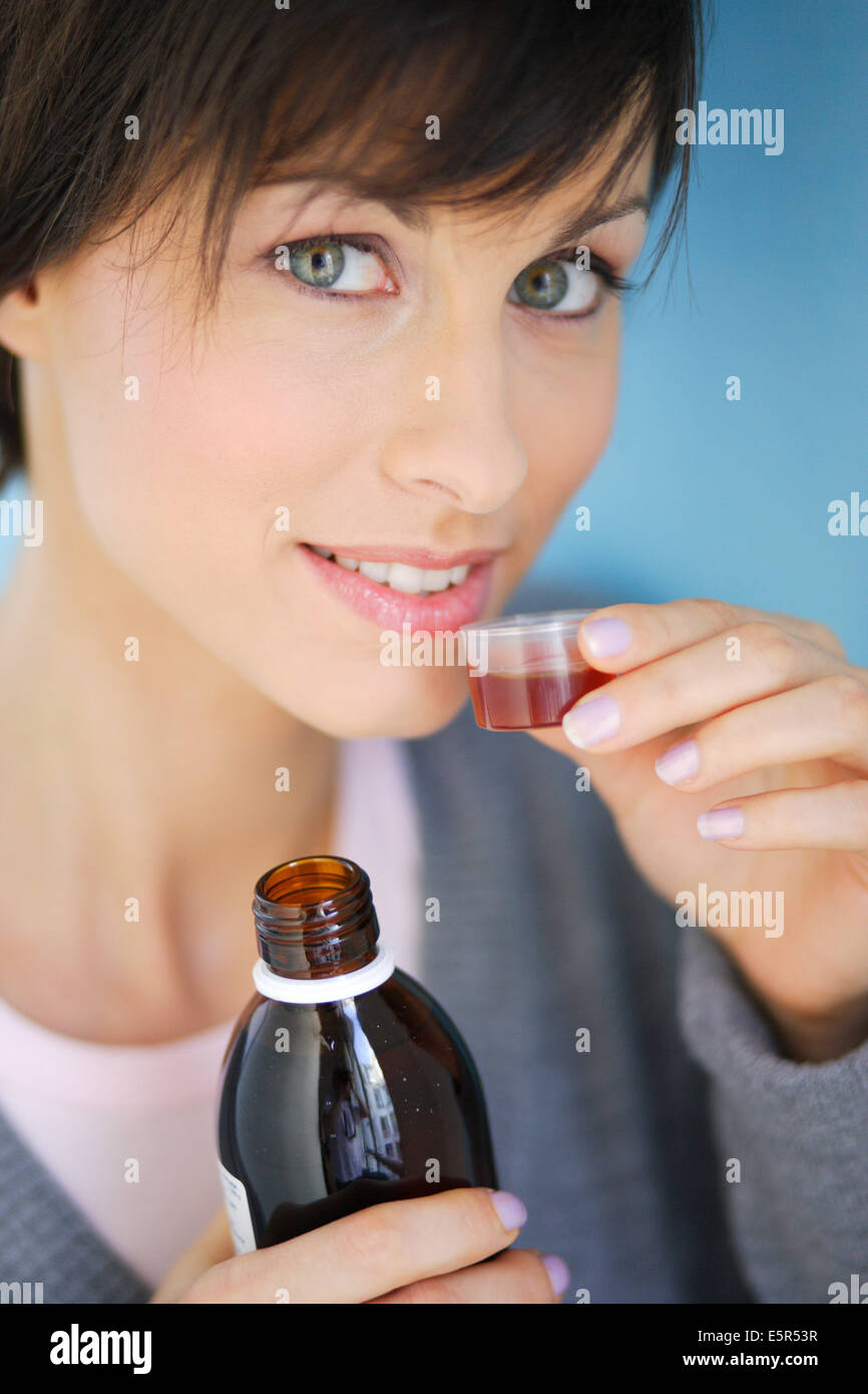Woman taking syrup Stock Photo - Alamy