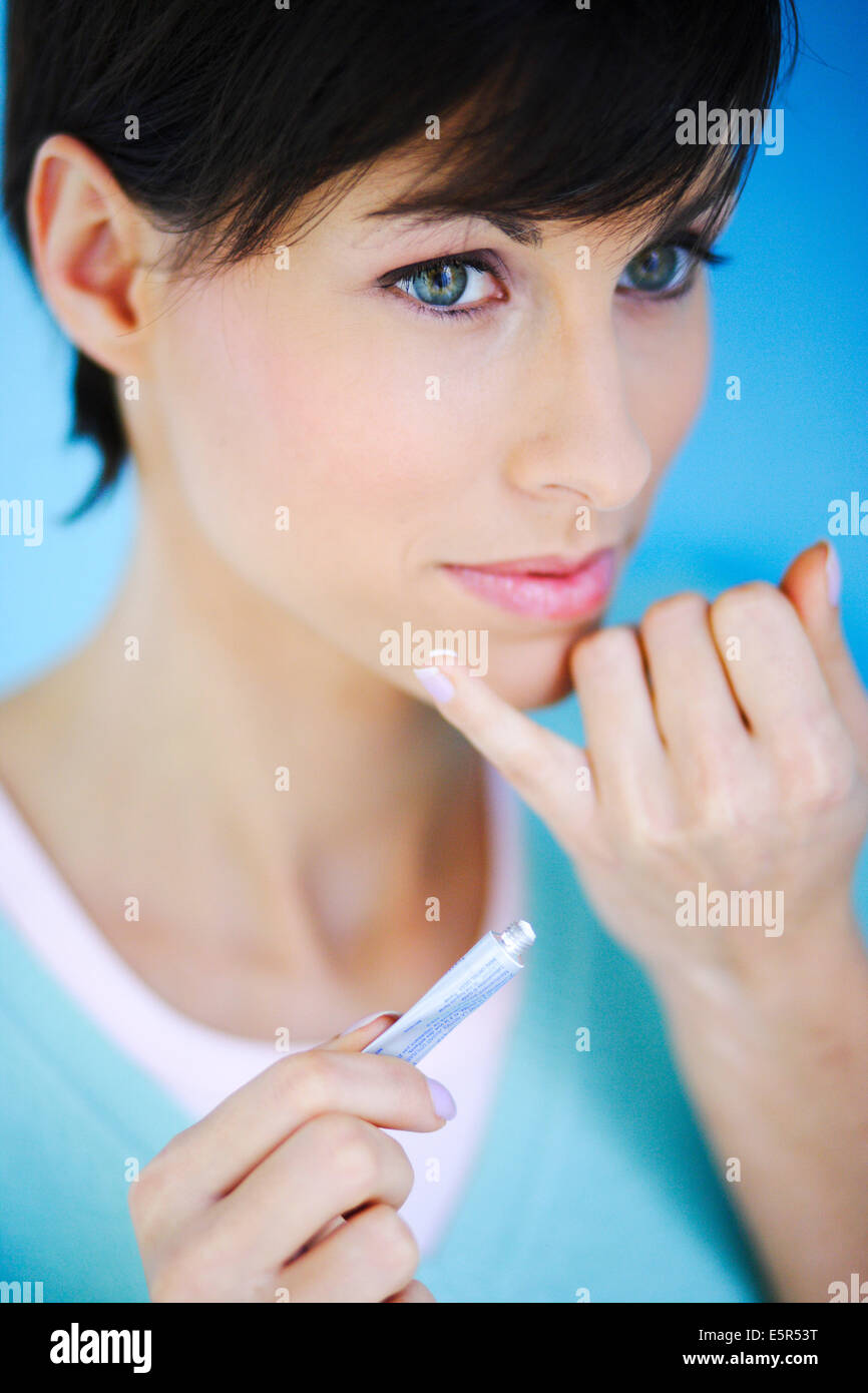 Woman applying cream on her lips as a treatment for a cold sore Stock ...