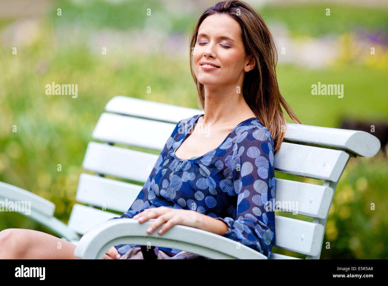 Woman sitting on a bench Stock Photo - Alamy