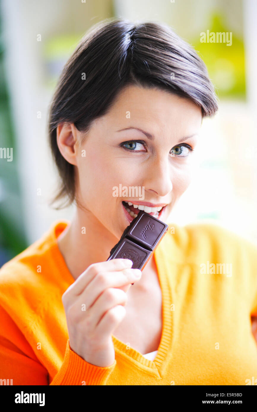 Woman eating chocolate Stock Photo - Alamy