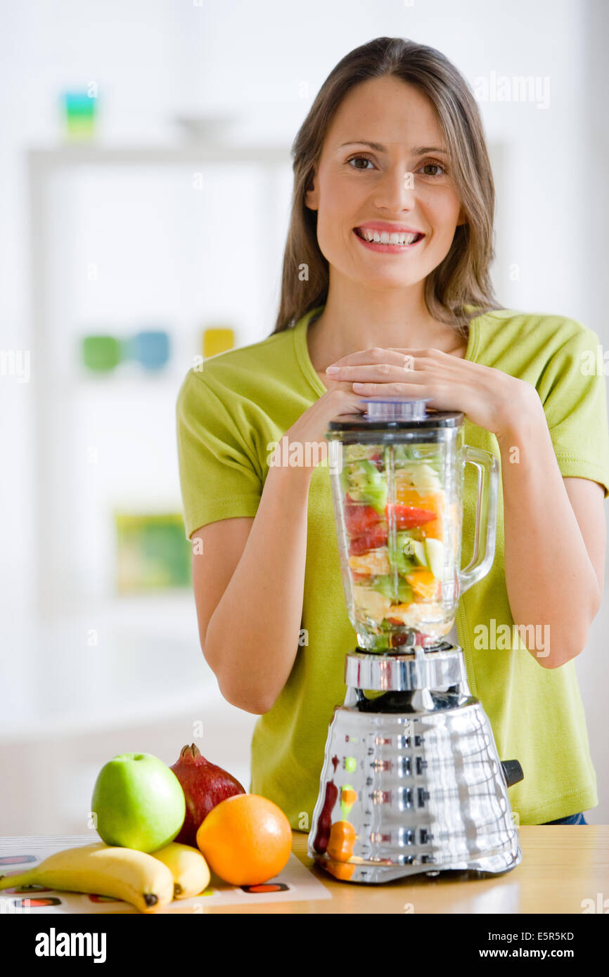 Woman making fruit smoothie in blender Stock Photo - Alamy