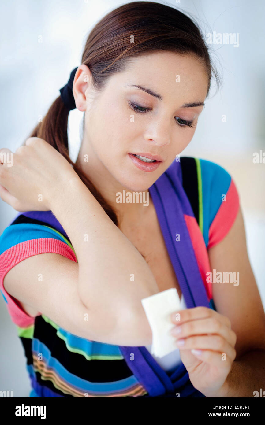 Woman applying gauze compress on her elbow Stock Photo - Alamy