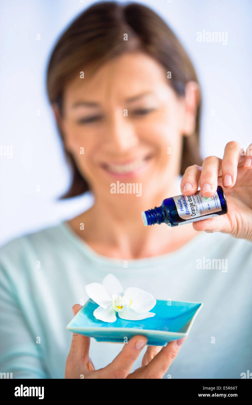 Woman using essential oil Stock Photo - Alamy
