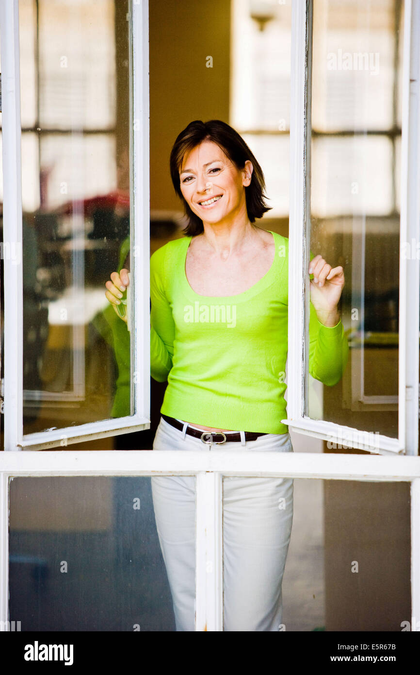 Woman opening window Stock Photo - Alamy