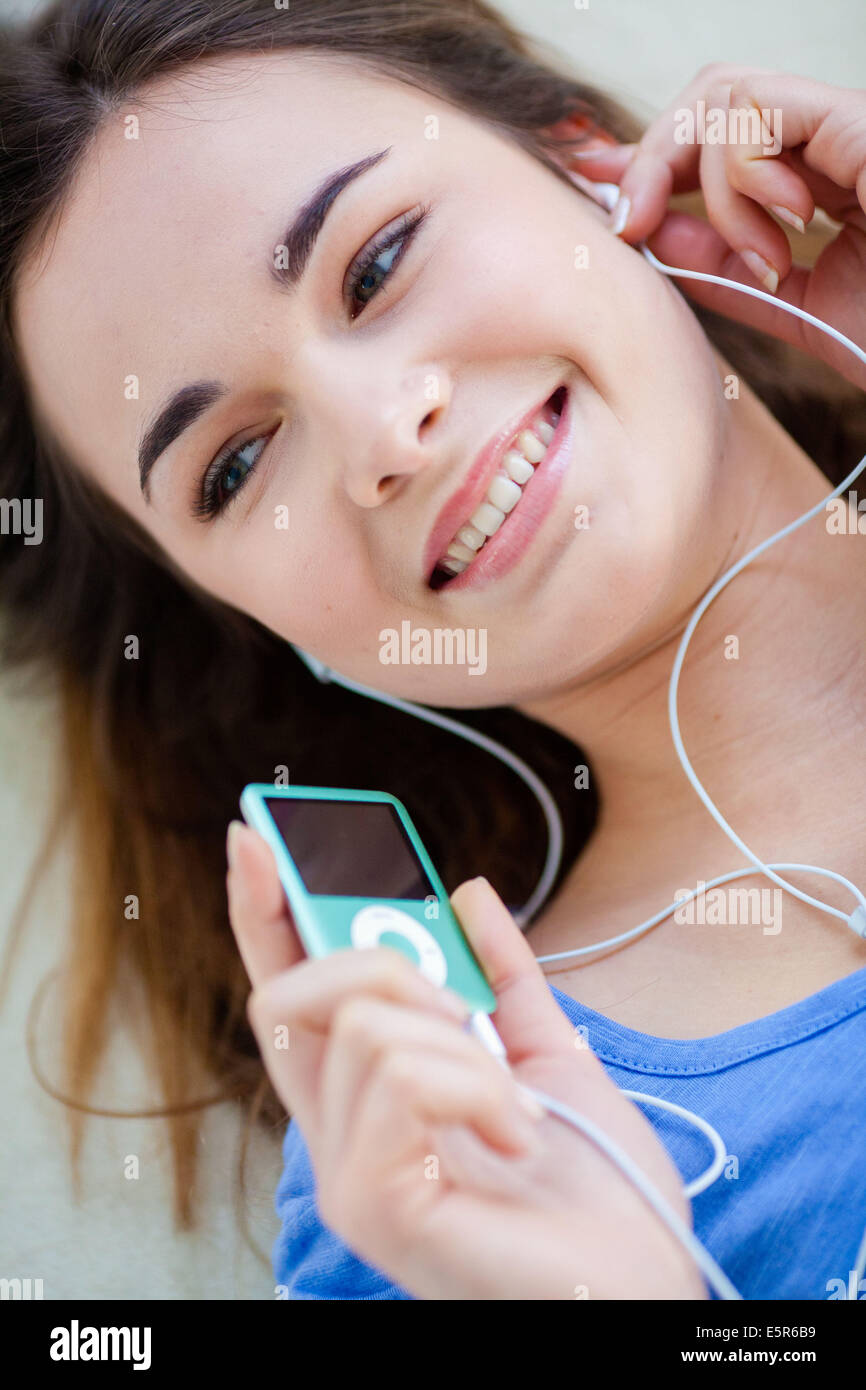 Woman listening to music on an ipod MP3 player Stock Photo - Alamy