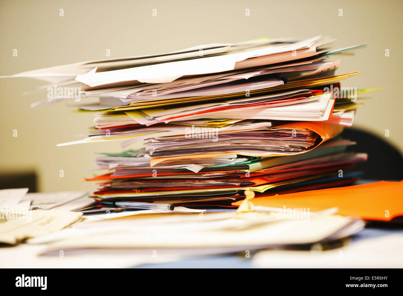 Files pilled up on desk Stock Photo - Alamy