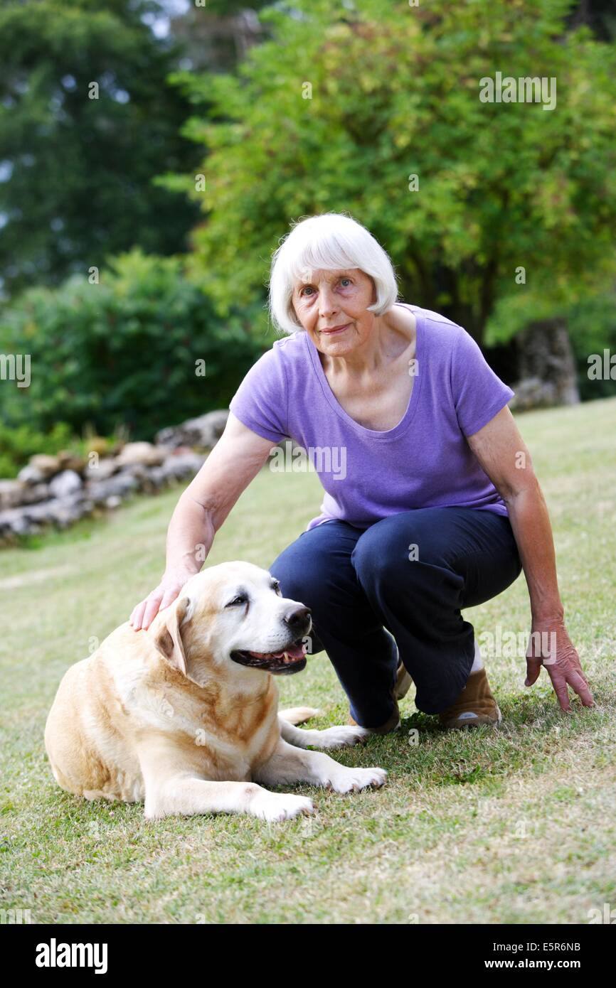 80 year old woman walking her dog Stock Photo - Alamy