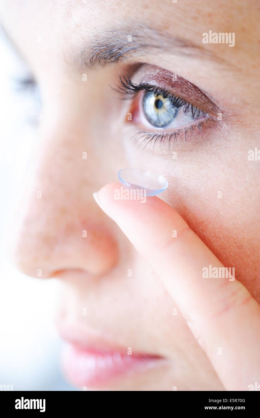Woman putting on contact lens Stock Photo - Alamy