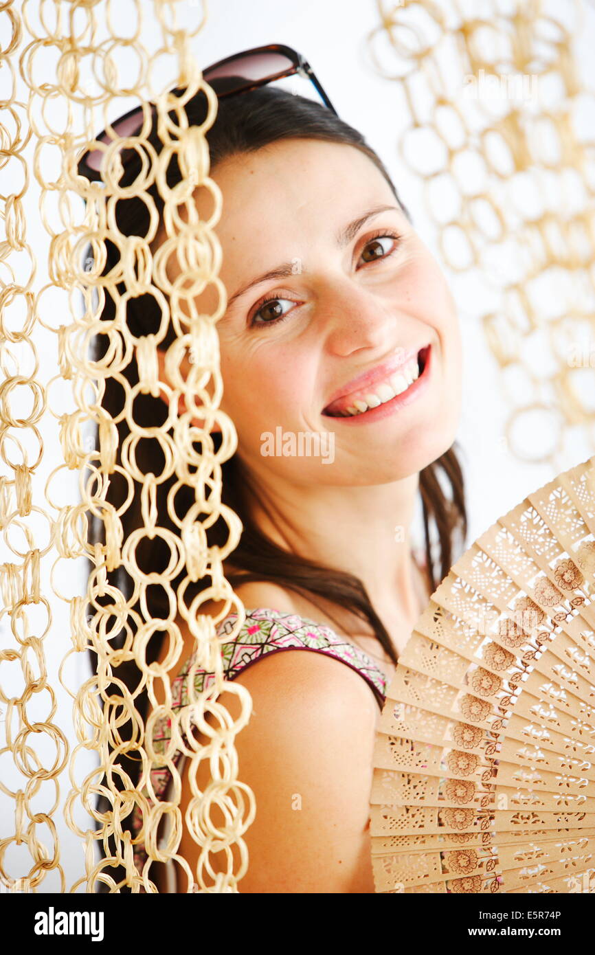 Woman cooling her face with a fan Stock Photo - Alamy