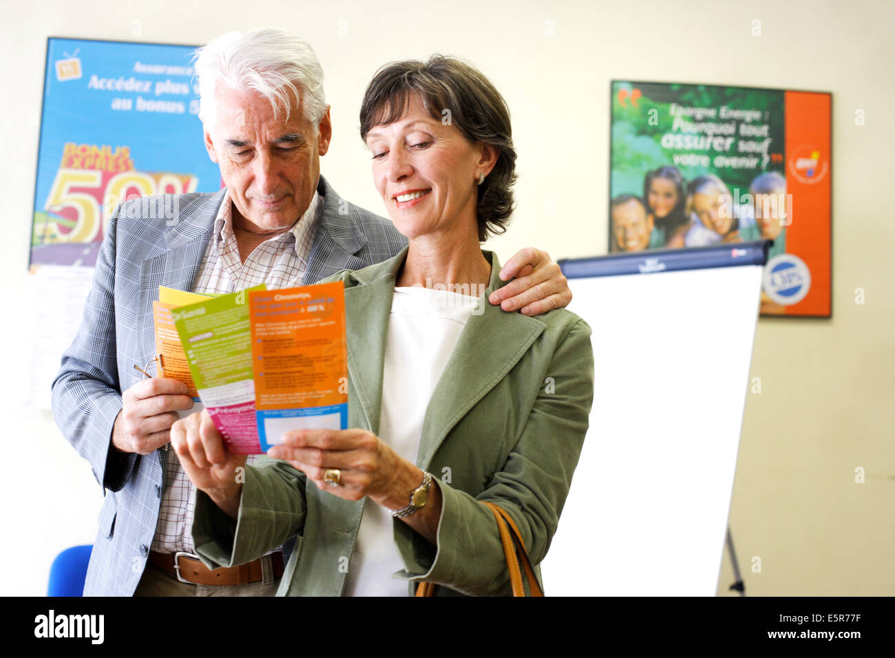 Senior couple waiting reading information brochures Stock Photo - Alamy
