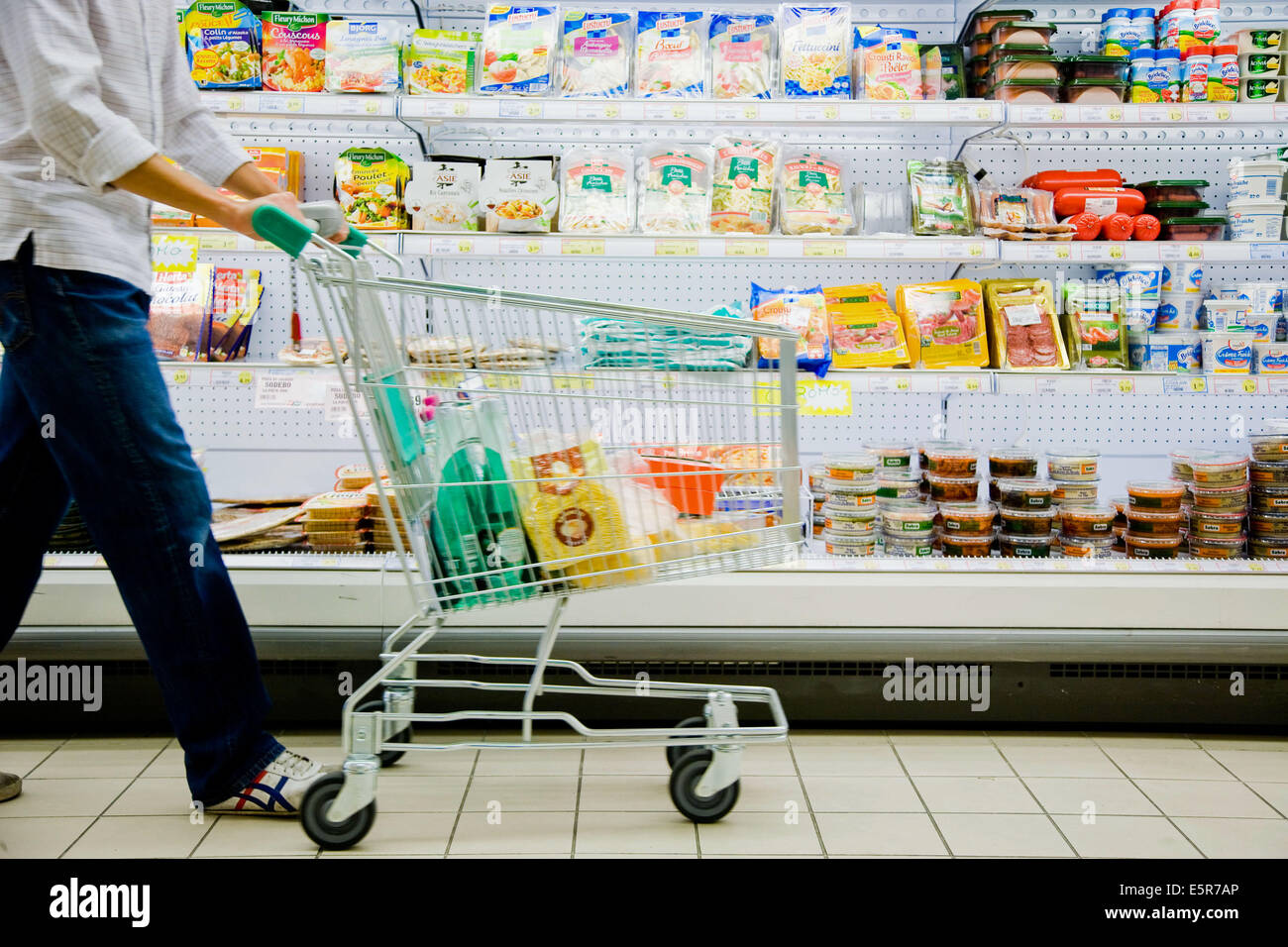 Man pushing shopping trolley in supermarket Stock Photo - Alamy