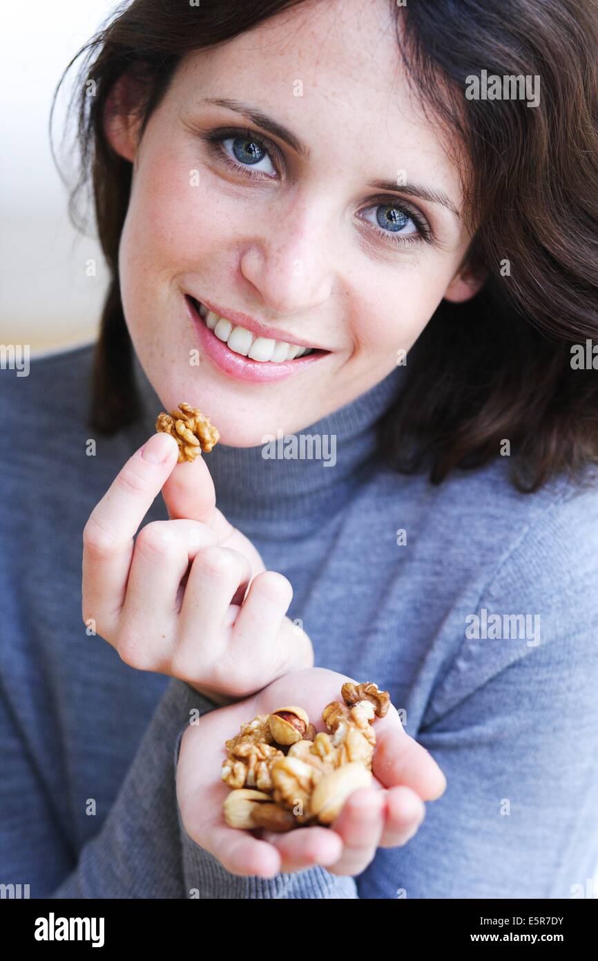 Woman eating walnuts Stock Photo - Alamy